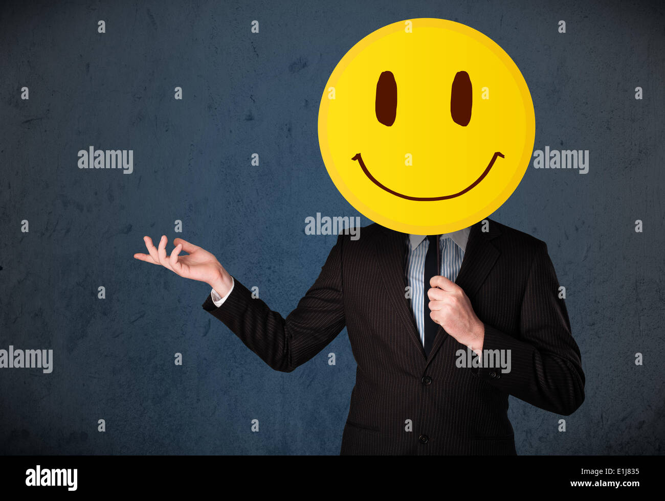 Businessman holding a smiley face emoticon Stock Photo - Alamy
