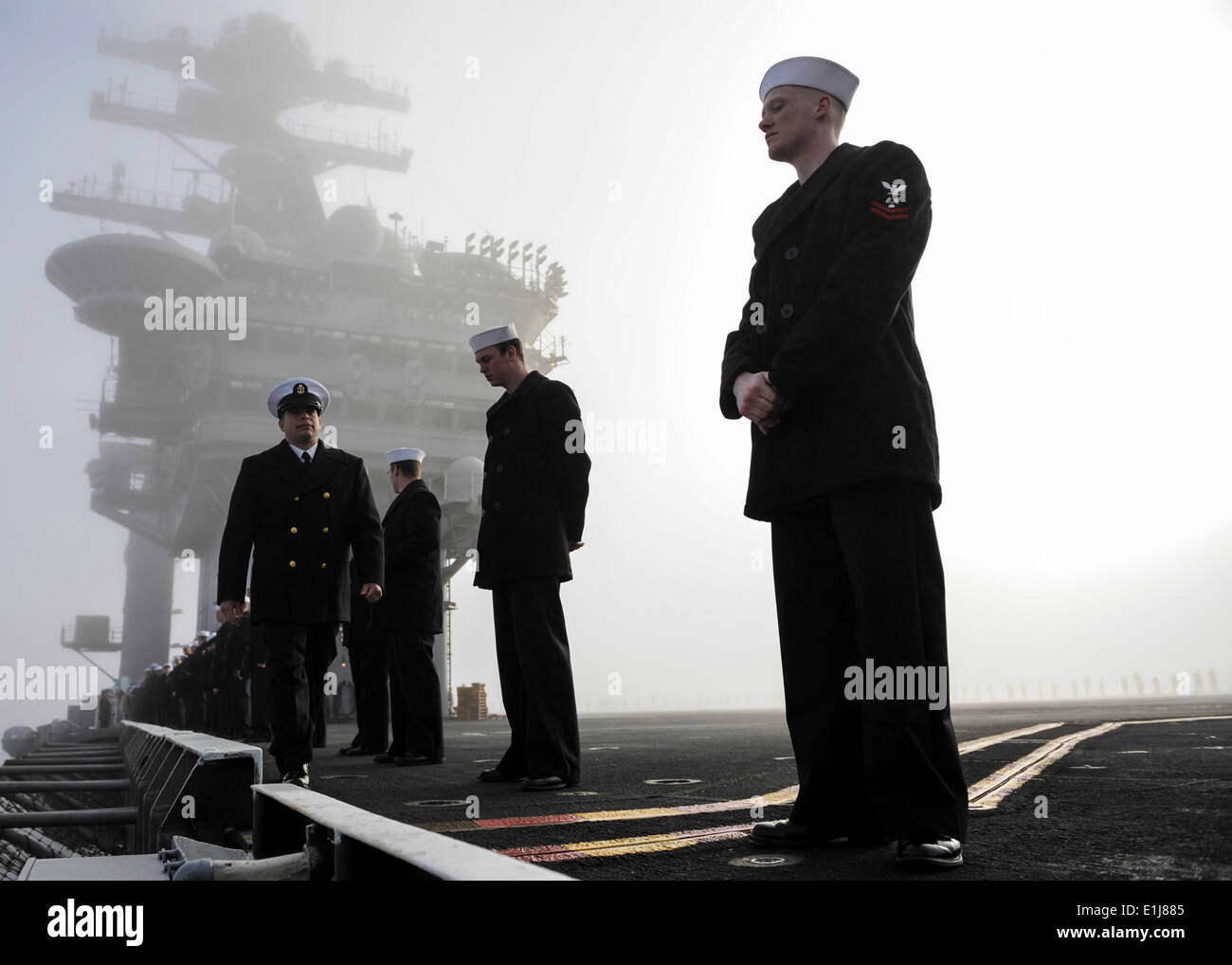 U.S. Sailors stand ready to man the rails aboard the aircraft carrier ...