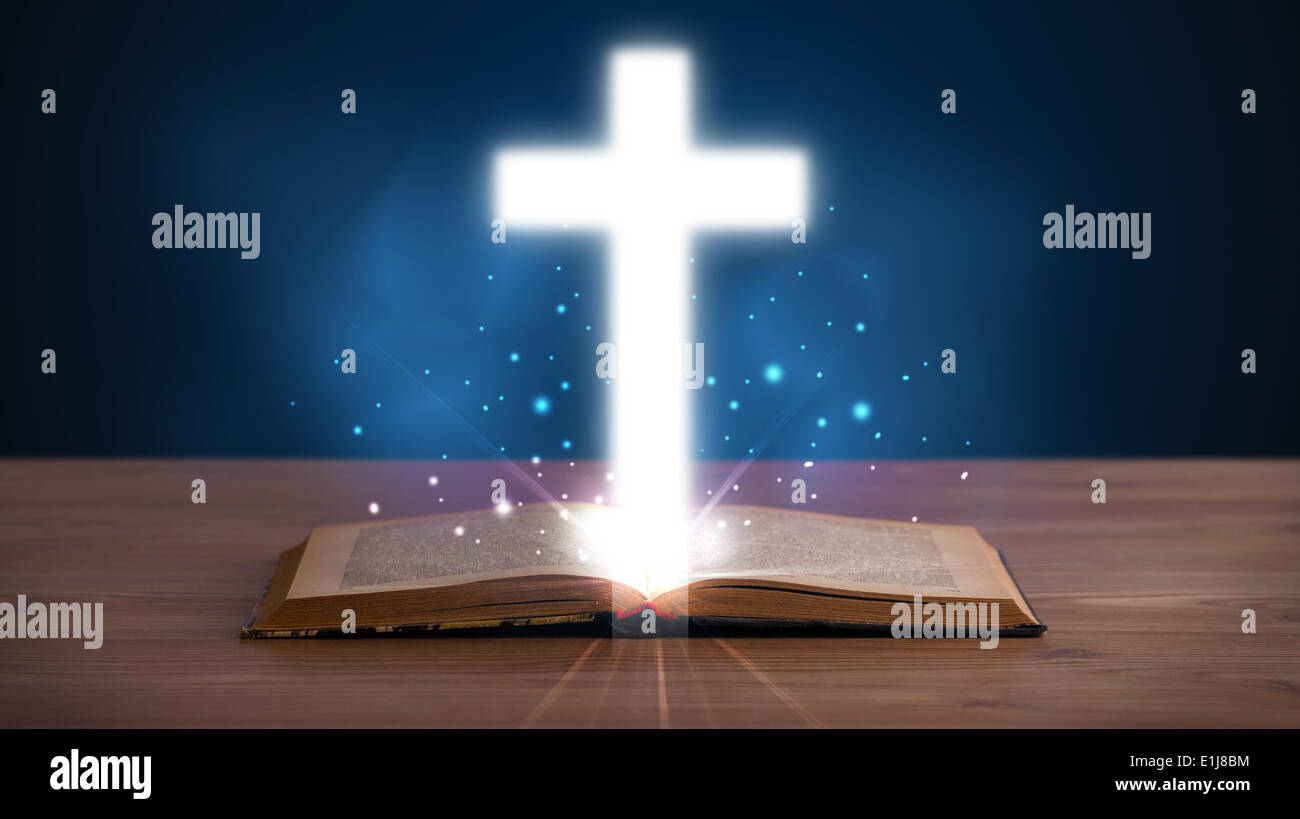 Open holy bible with glowing cross in the middle Stock Photo - Alamy