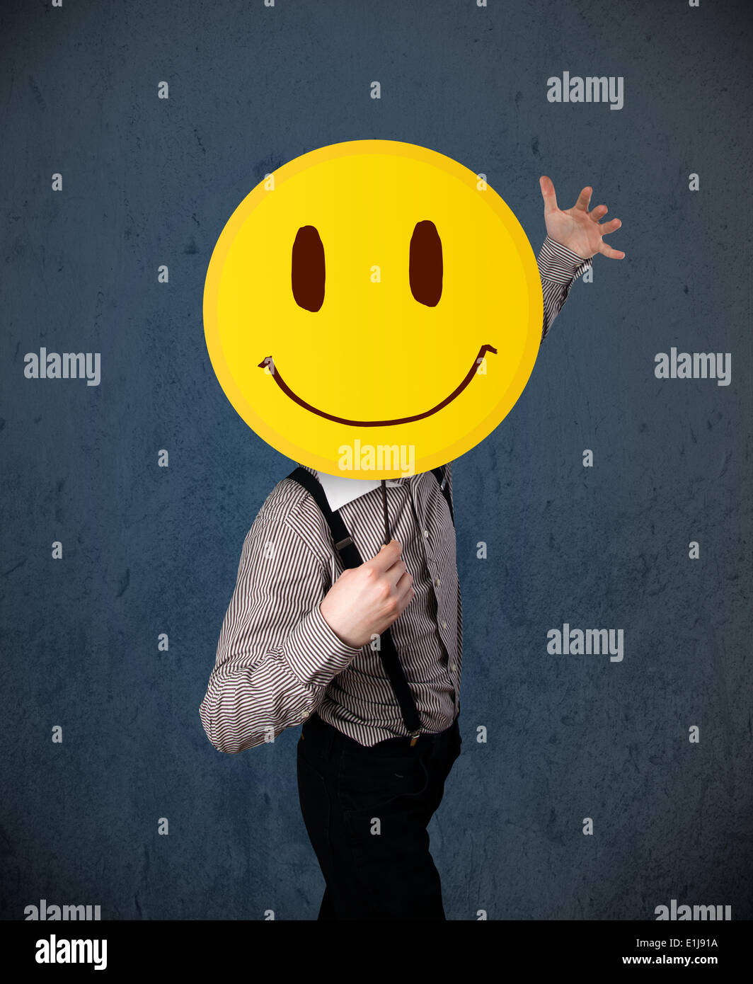 Businessman holding a smiley face emoticon Stock Photo - Alamy