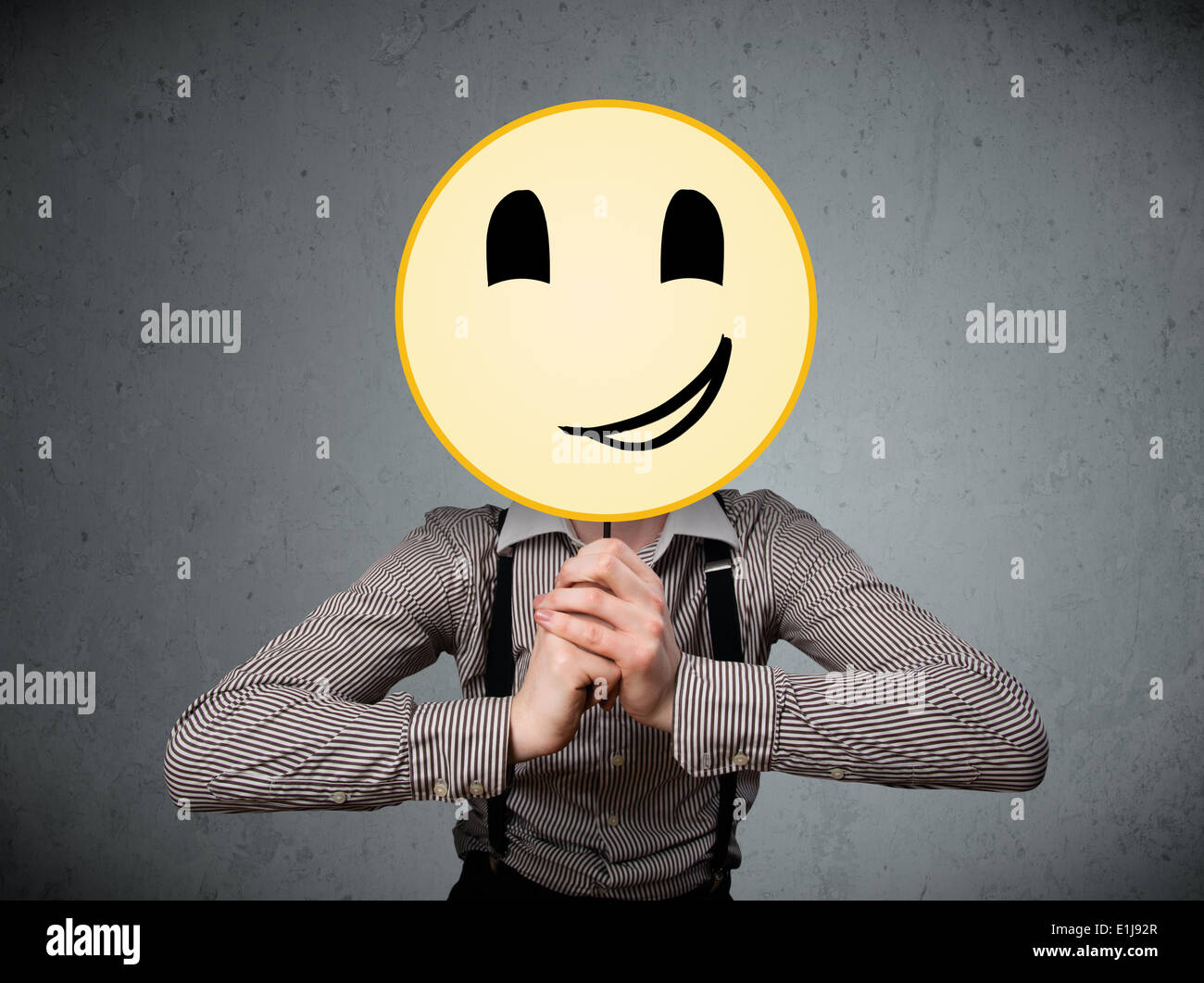 Businessman holding a smiley face emoticon Stock Photo - Alamy