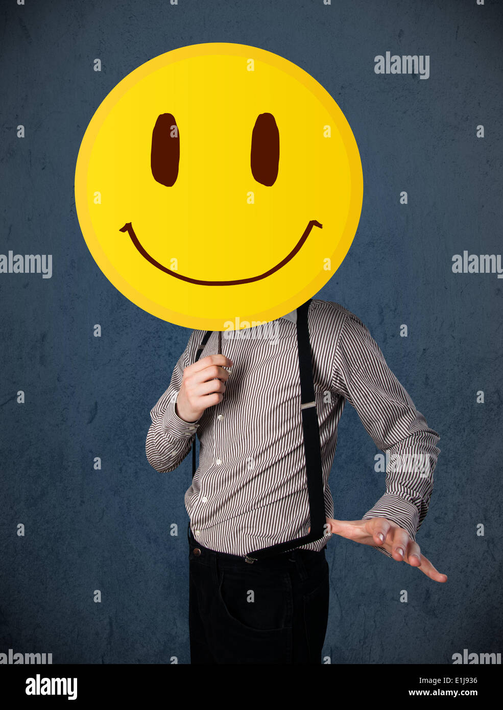 Businessman holding a smiley face emoticon Stock Photo - Alamy