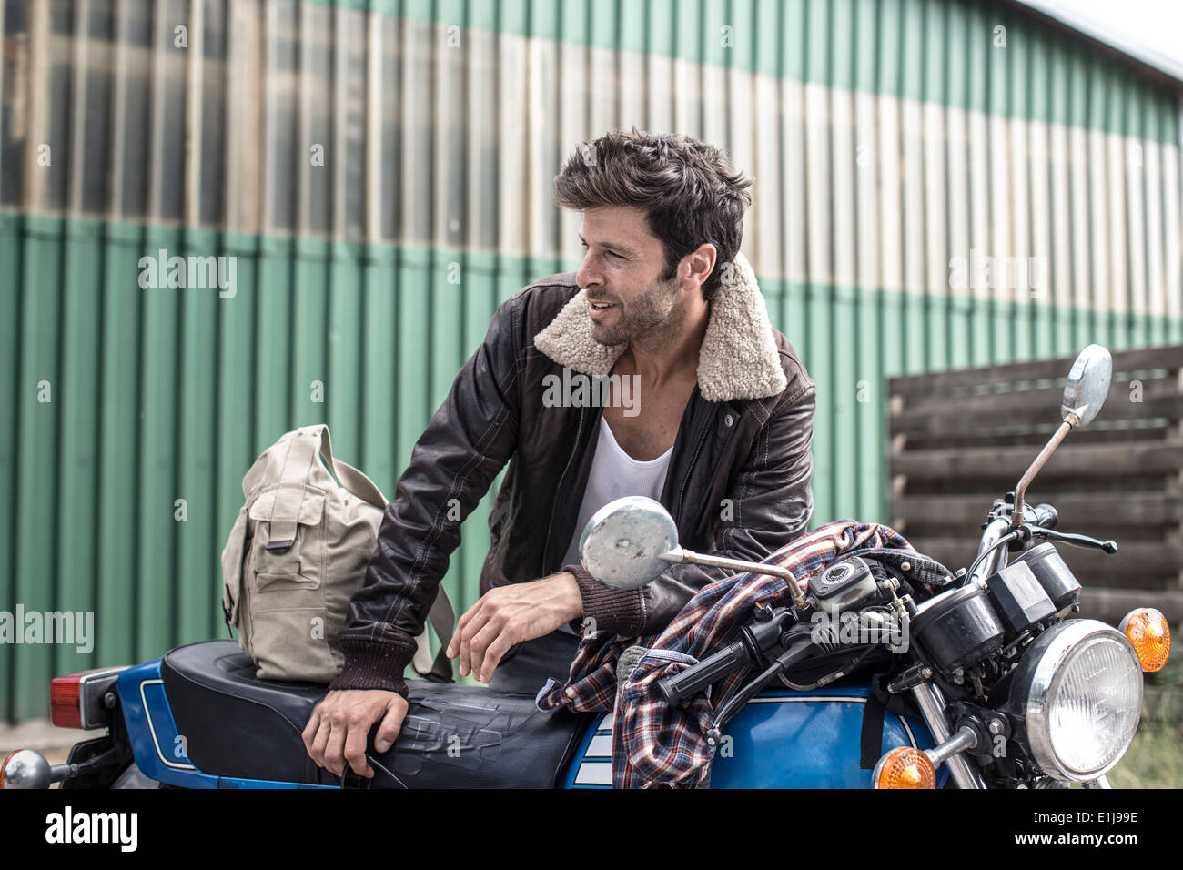 Portrait of man leaning on motorcycle Stock Photo - Alamy