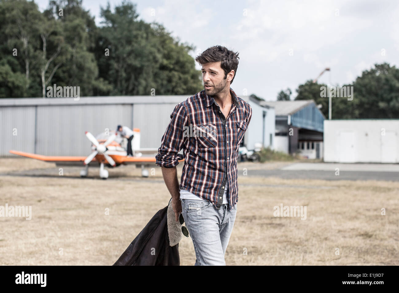 Man walking in front of propeller plane Stock Photo - Alamy