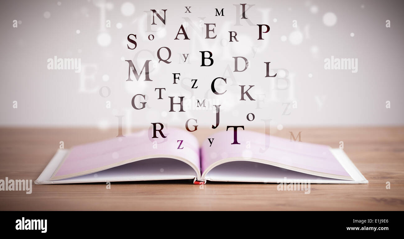 Opened book with flying letters Stock Photo - Alamy