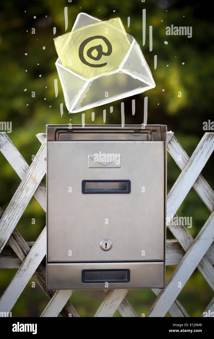 Envelope with email sign dropping into mailbox Stock Photo - Alamy