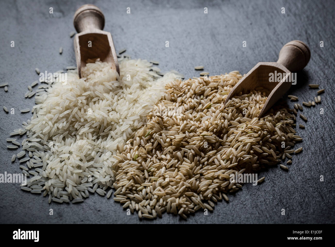 Wooden shovels organic brown rice and jasmine rice on slate Stock Photo ...