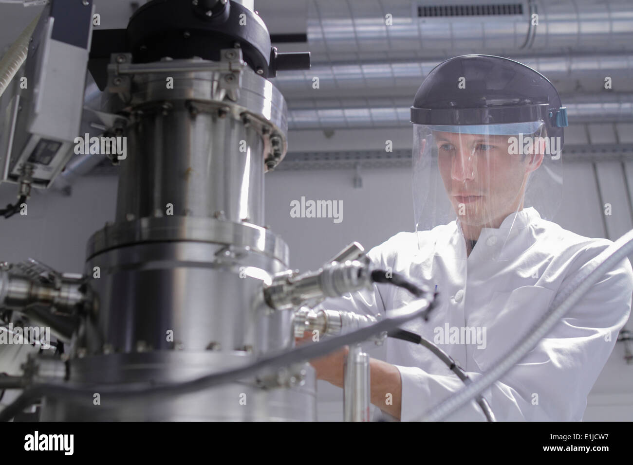 Scientist standing in analytical laboratory with scanning electron ...