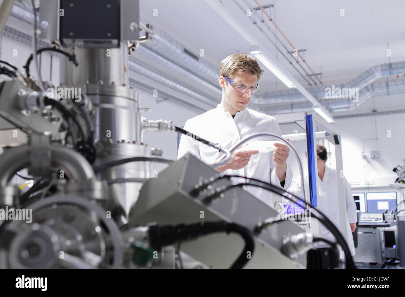 Scientist standing in analytical laboratory with scanning electron ...