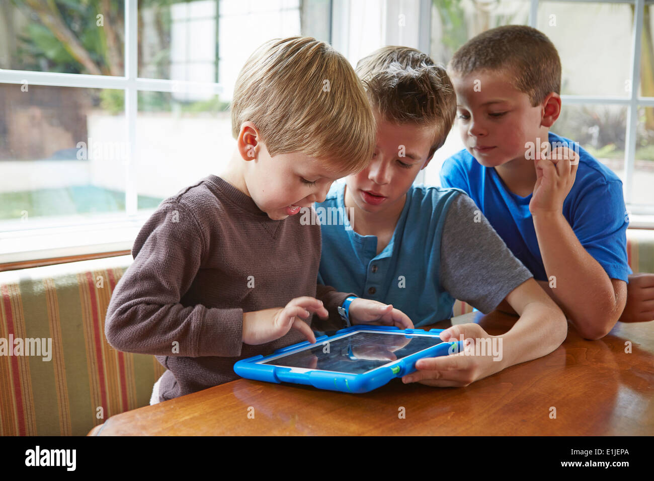 Three boys playing with digital tablet Stock Photo - Alamy