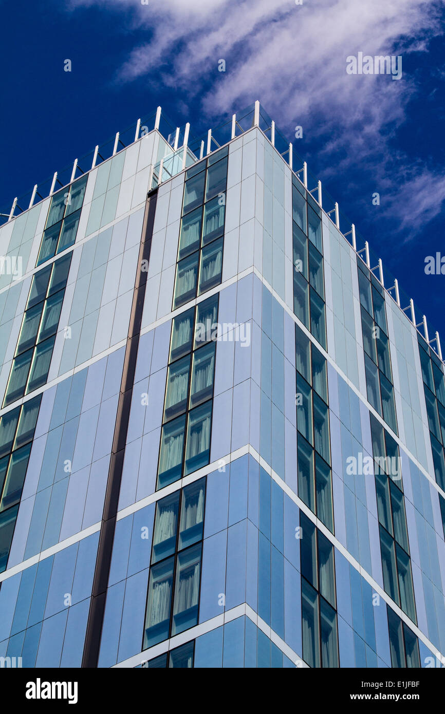 Modern hotel building against deep blue sky with single cloud formation ...