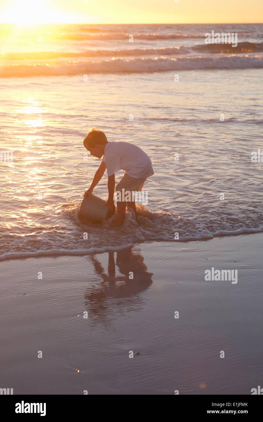 Boy fetching sea water with bucket Stock Photo - Alamy