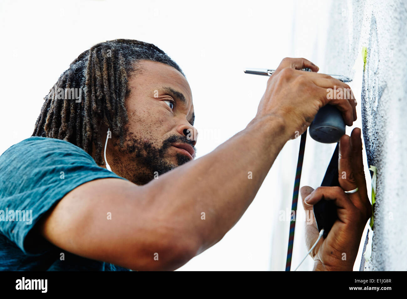 Close up of male african american airbrush artist painting mural Stock ...