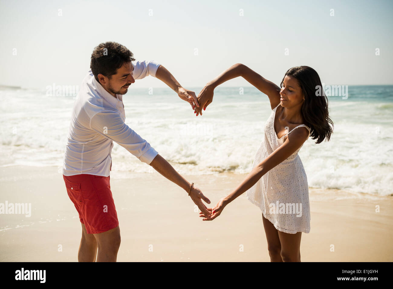Couple making heart shape with arms on Arpoador beach, Rio De Stock ...