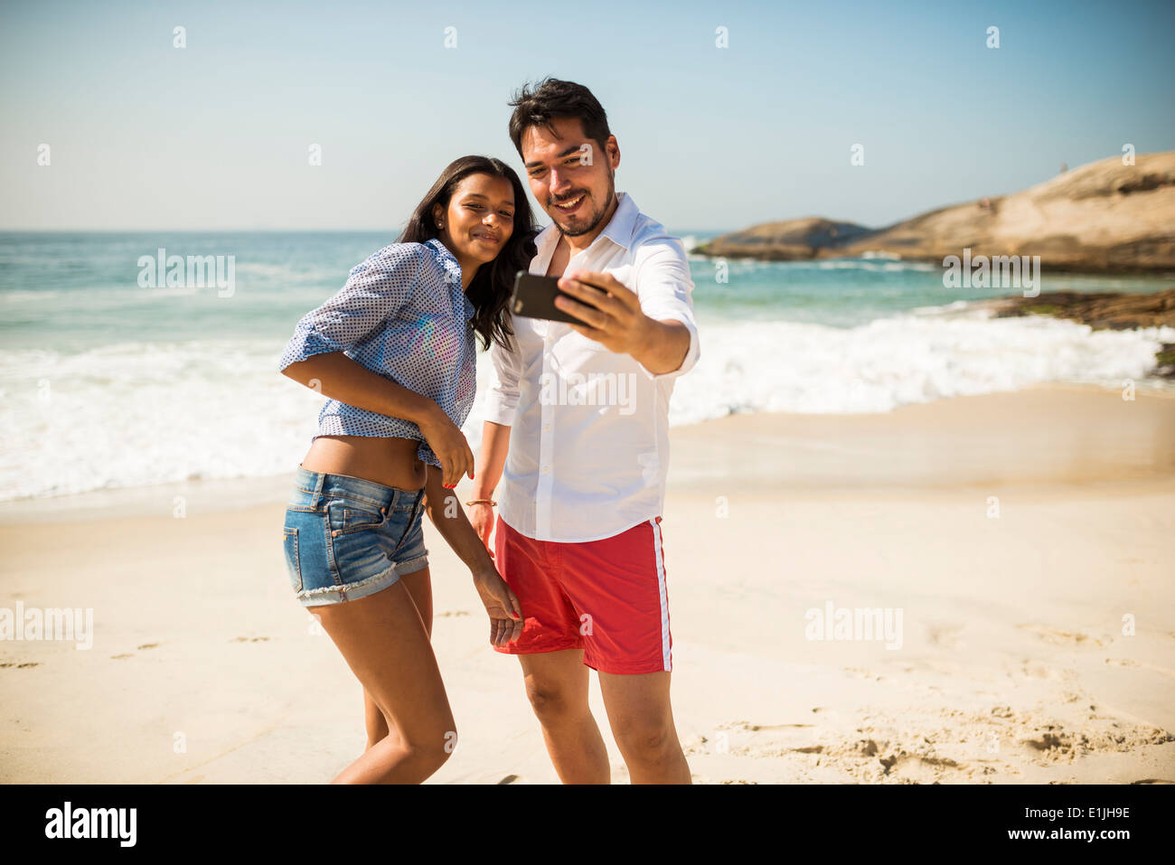 Couple taking selfie on smartphone, Arpoador beach, Rio De Janeiro ...
