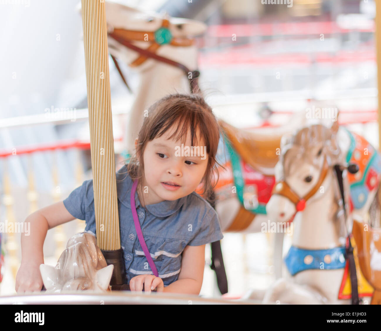 Young girl riding carousel horse at amusement park Stock Photo - Alamy