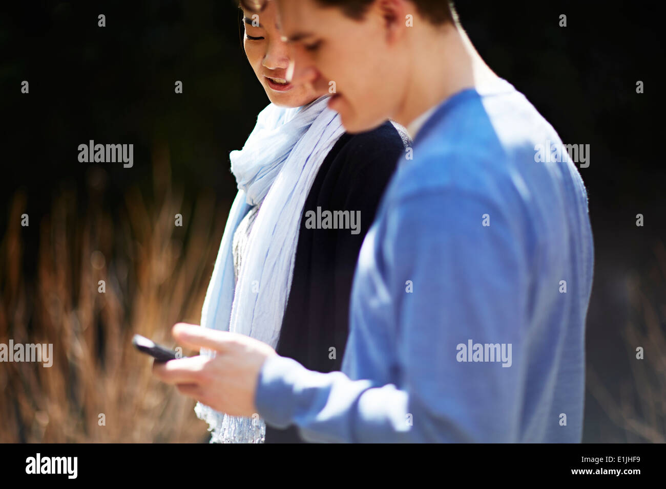 Young couple, man using cell phone Stock Photo - Alamy