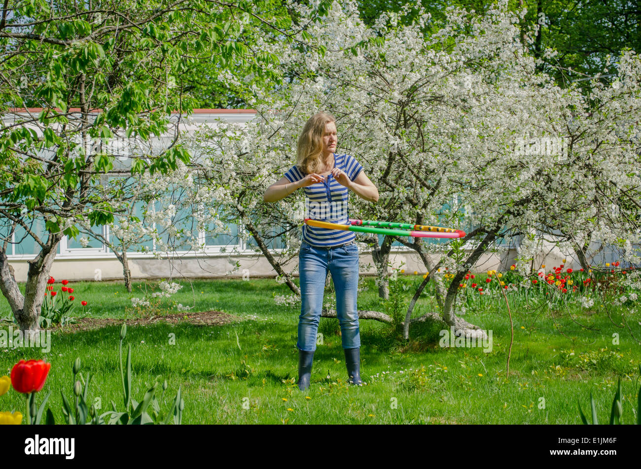 girl turning hula hoop between flowering cherry tree to have a perfect ...