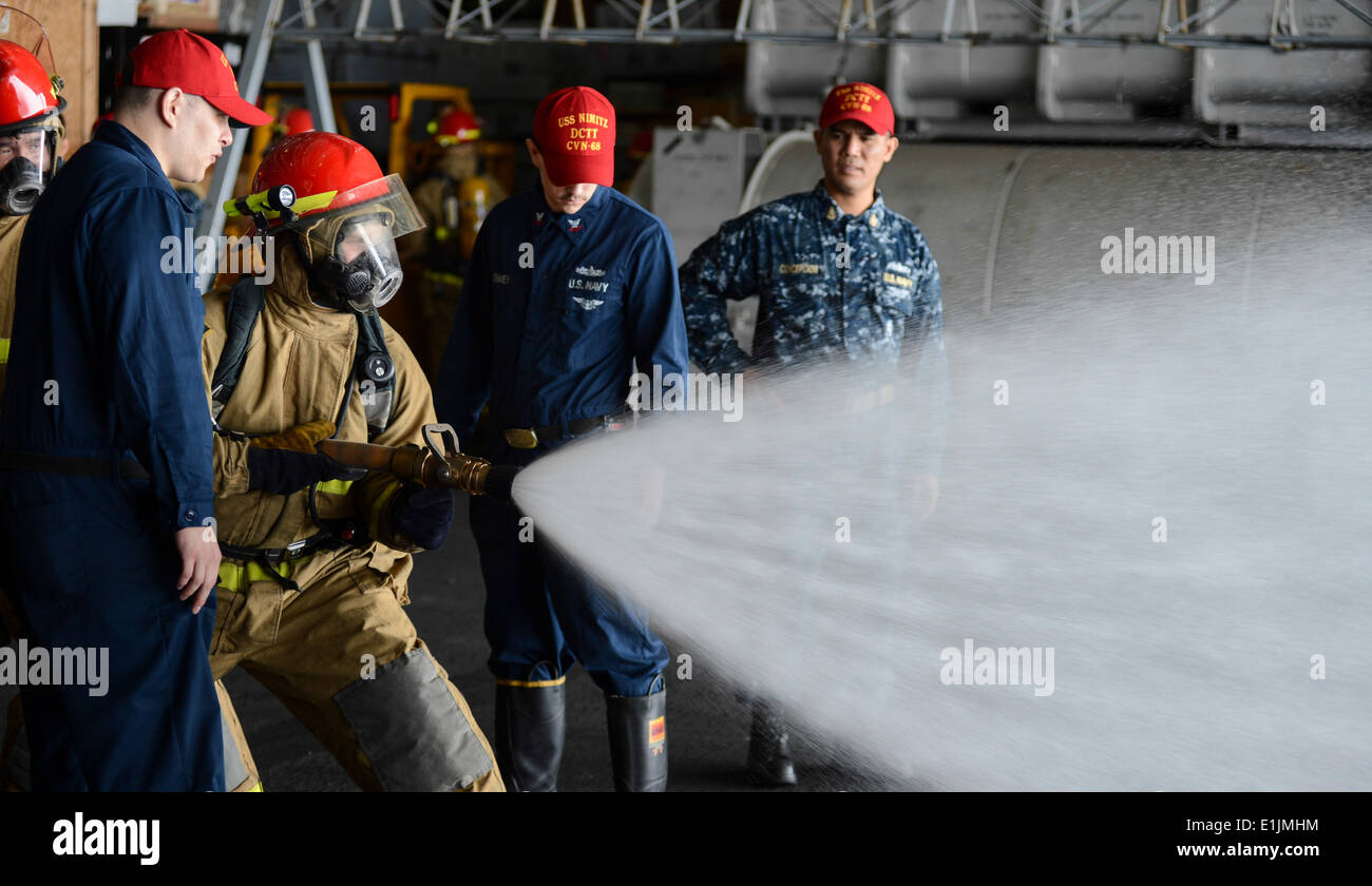 U.S. Sailors participate in a firefighting exercise during a general ...