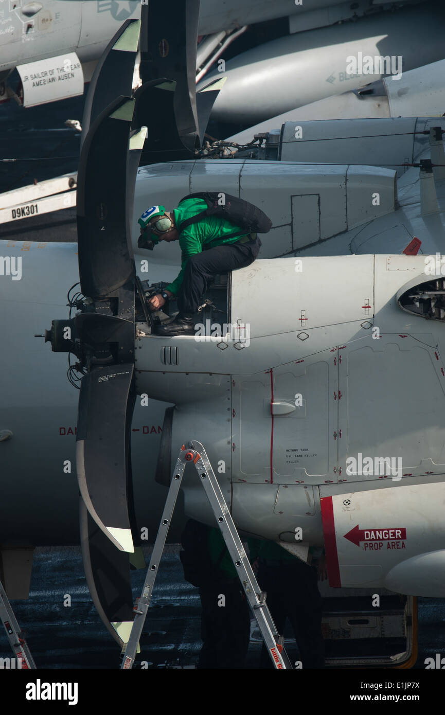 A U.S. Sailor performs maintenance on an E-2C Hawkeye aircraft assigned ...