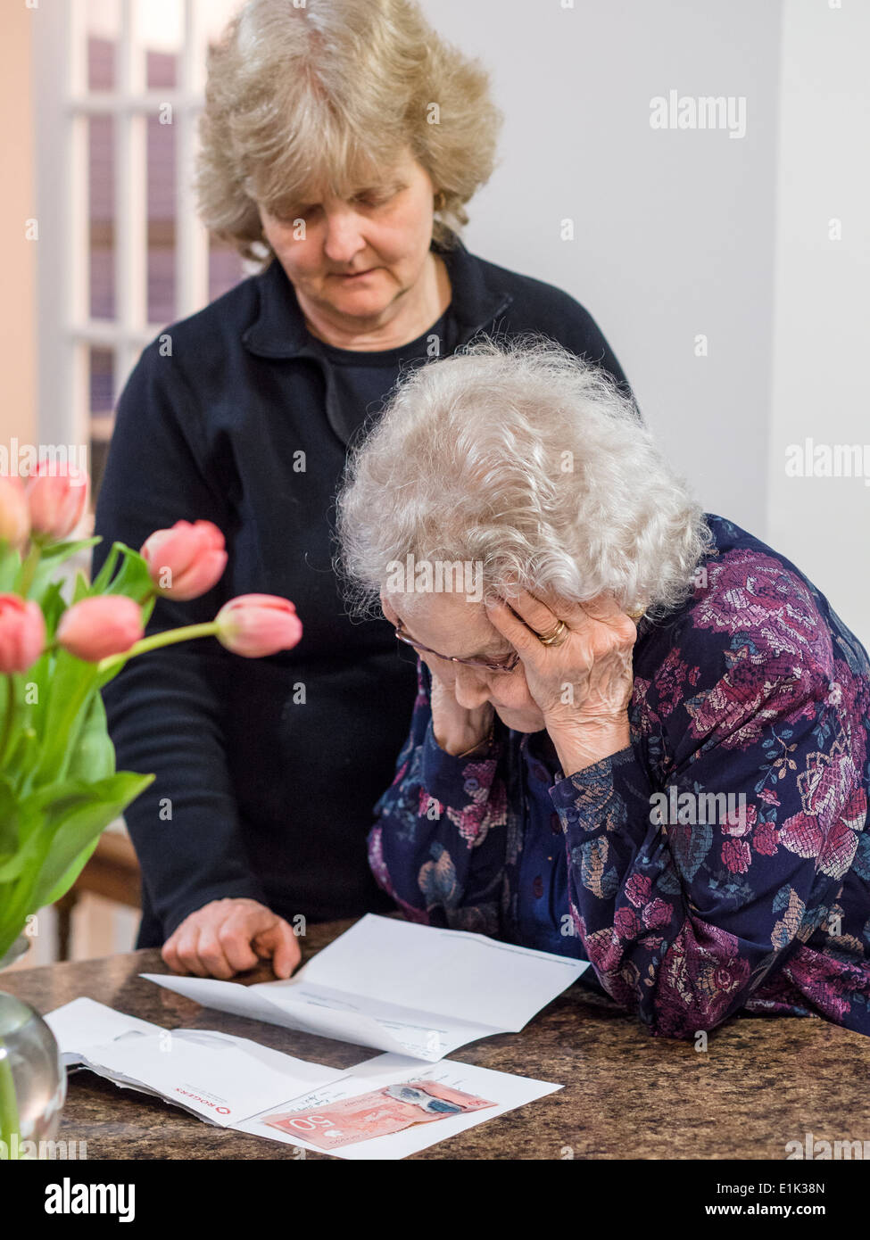 Reading a Letter. A senior woman reads a letter with her head in her ...