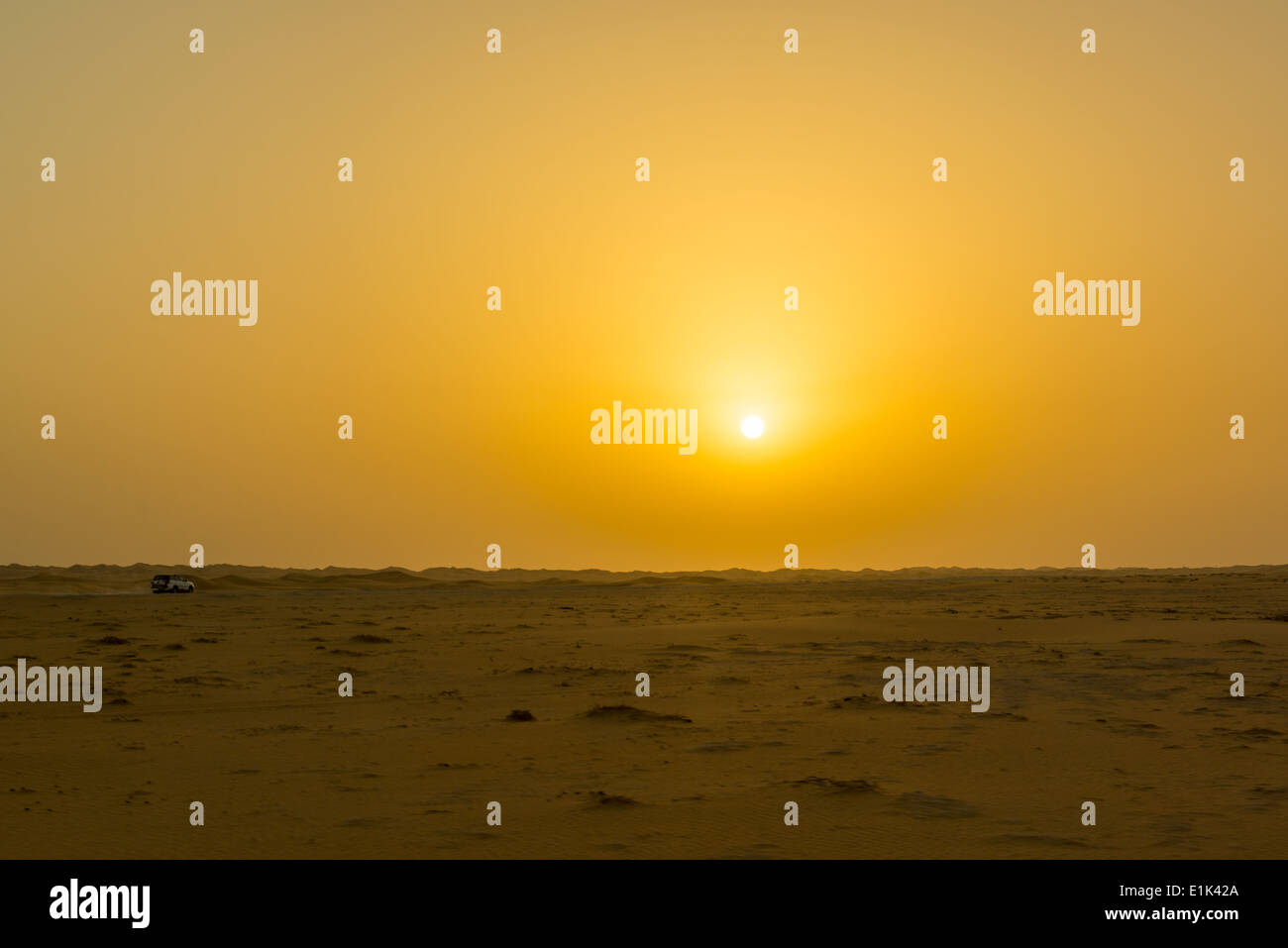 Setting sun in the desert Stock Photo - Alamy