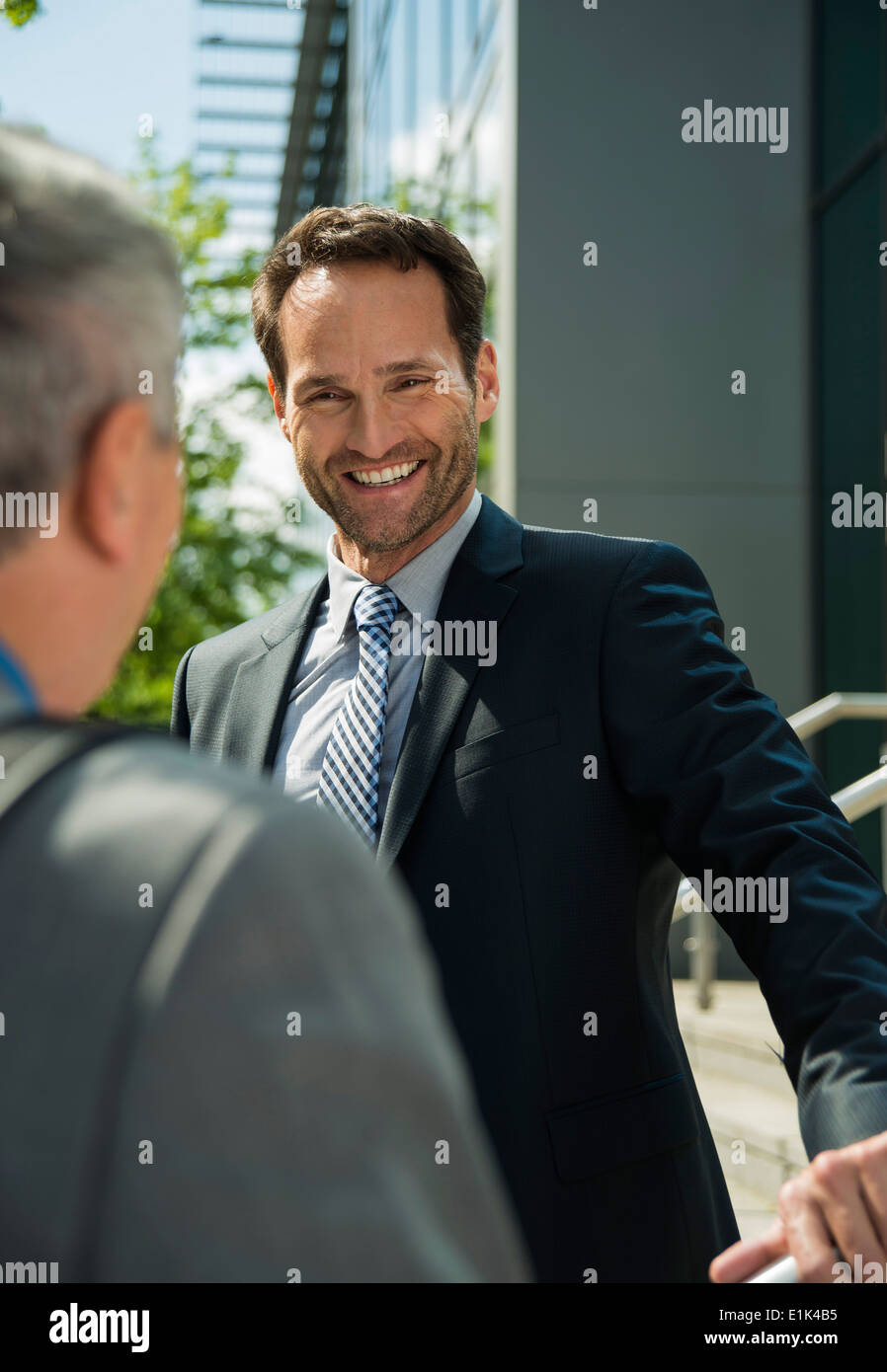 Two smiling businessmen outside office building Stock Photo - Alamy
