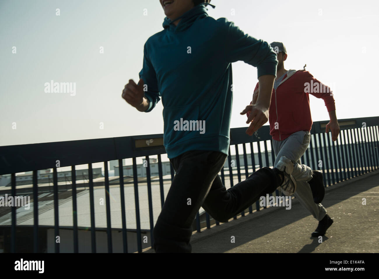 Young man and teenager running on bridge Stock Photo - Alamy