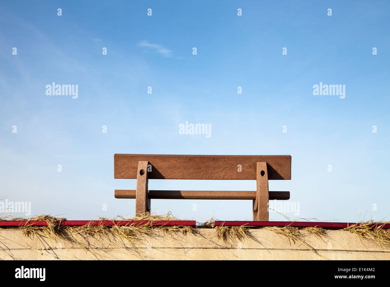 Germany, Lower Saxony, Dornum, wooden bench at waterfront promenade ...