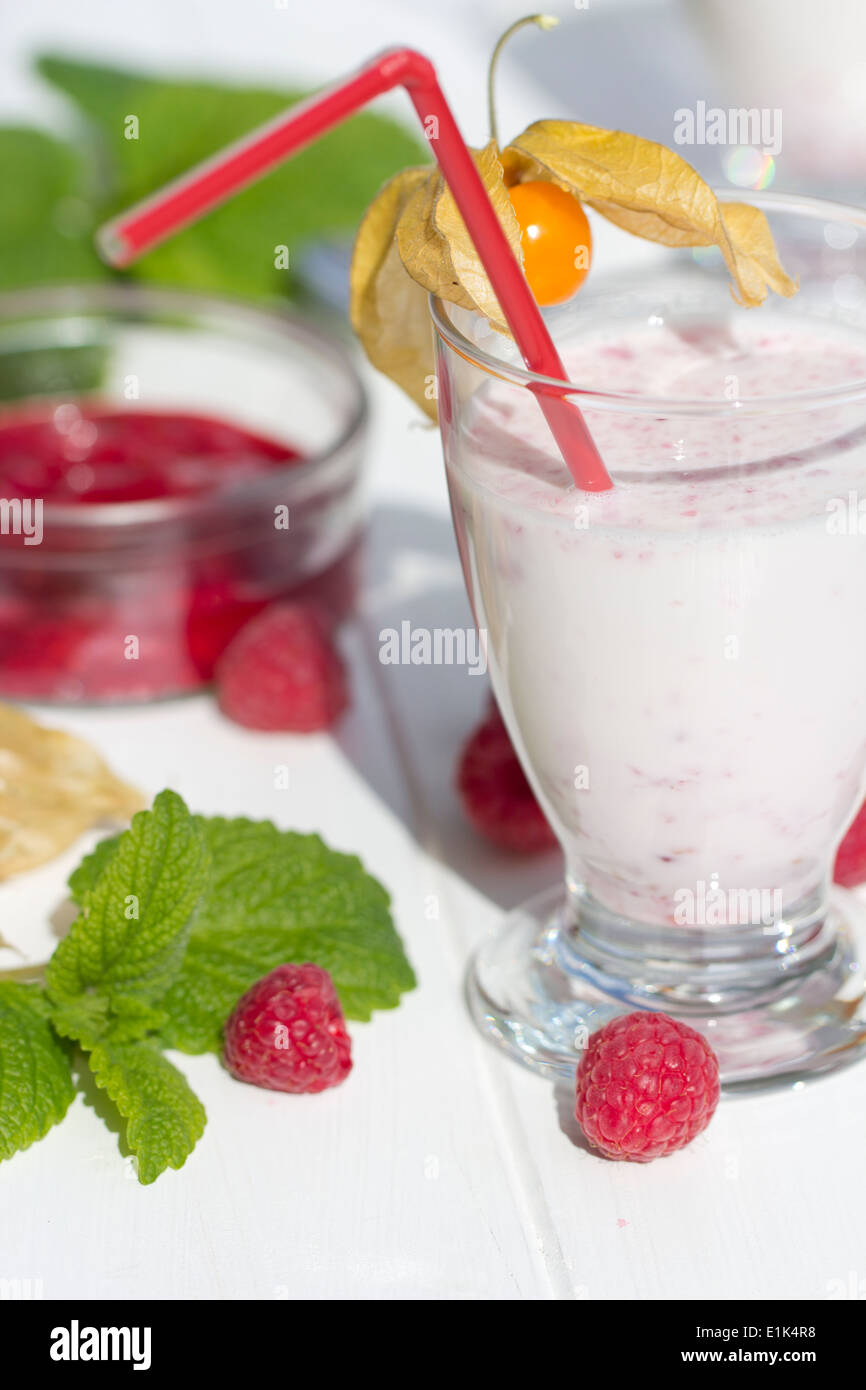 Raspberry milk with drinking straw and physalis, mashed raspberries in ...
