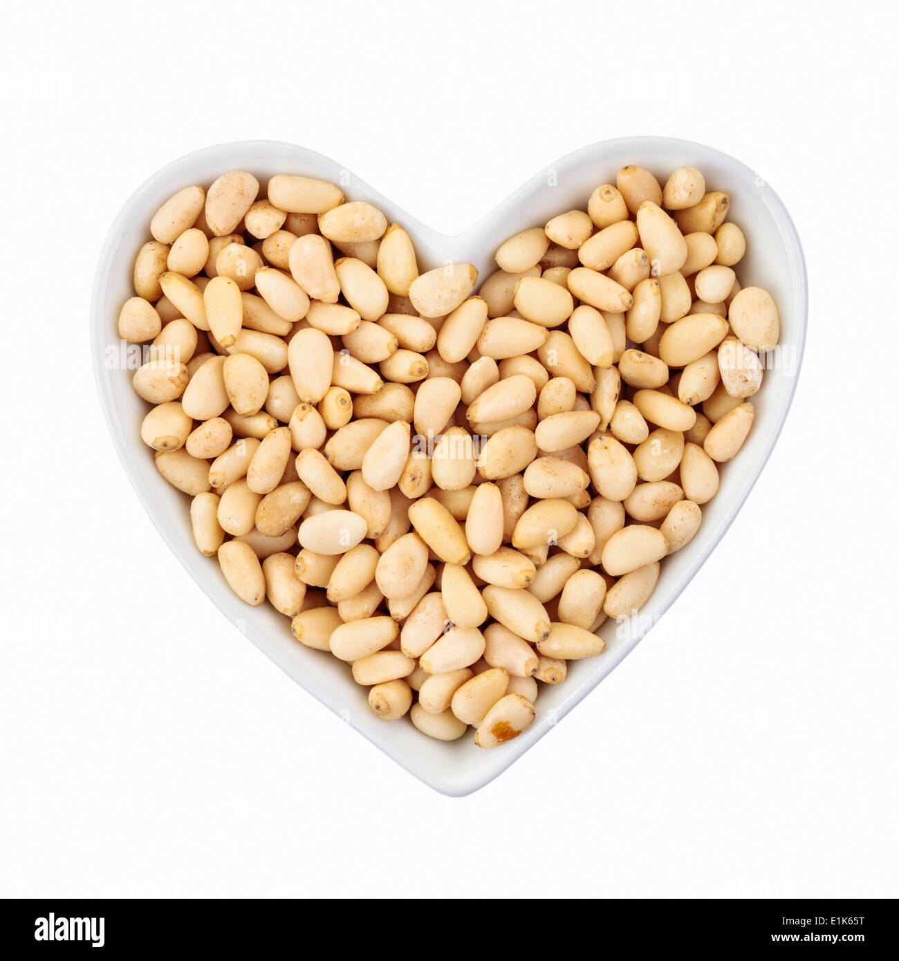 Shelled Pine nuts in a heart-shaped dish Stock Photo - Alamy