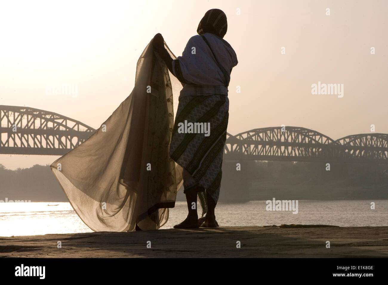 Woman unfolding a sari along the Ganga river Stock Photo - Alamy