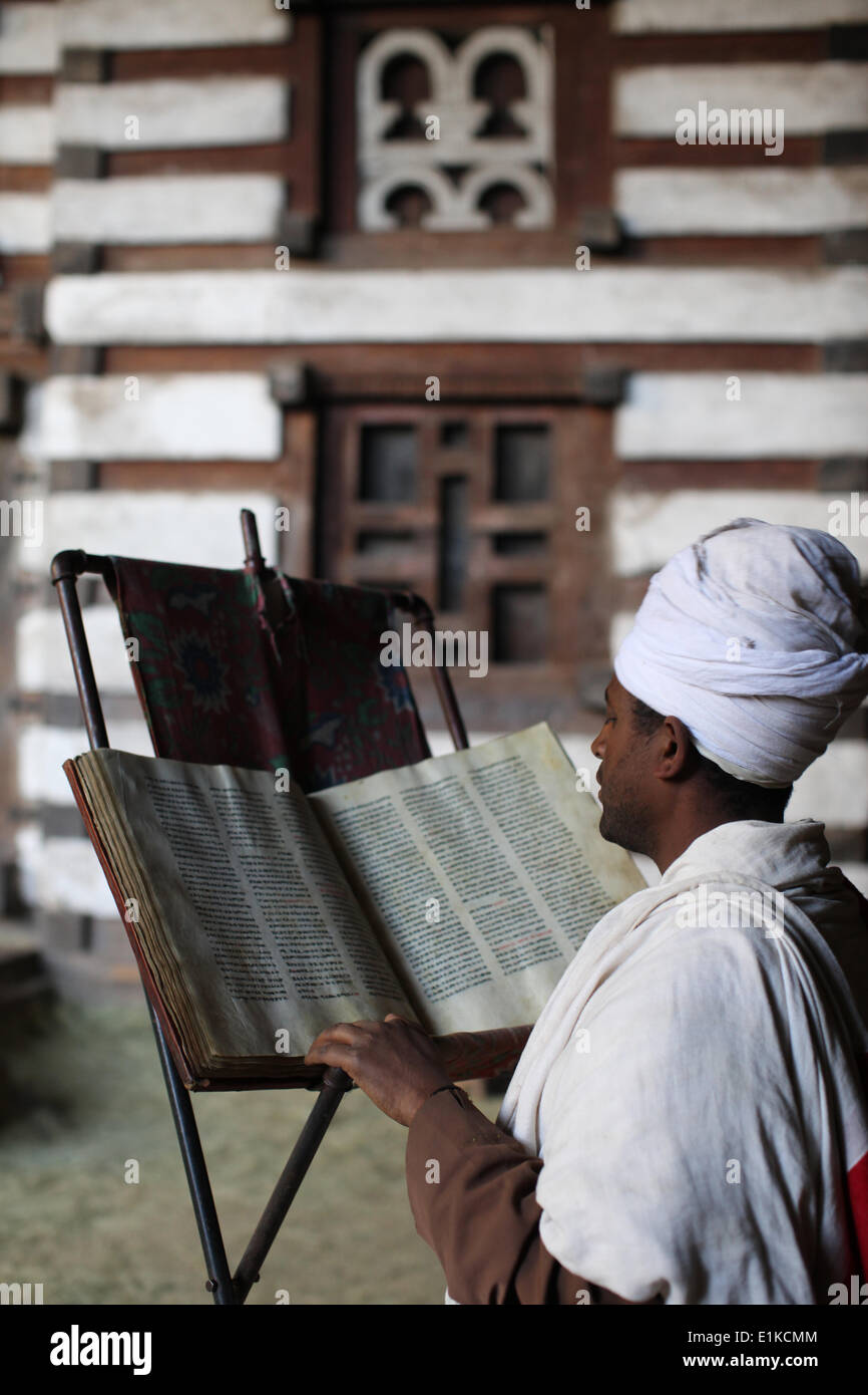 Priest reading a Bible at St. Yimrhane Kristos cave church Stock Photo ...