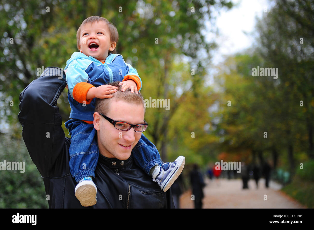 Child sitting on his father's shoulders Stock Photo - Alamy