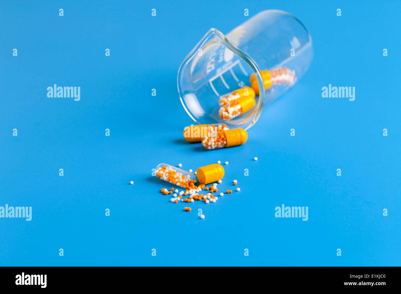 Medicine capsules broken in half with contents spilling out Stock Photo ...