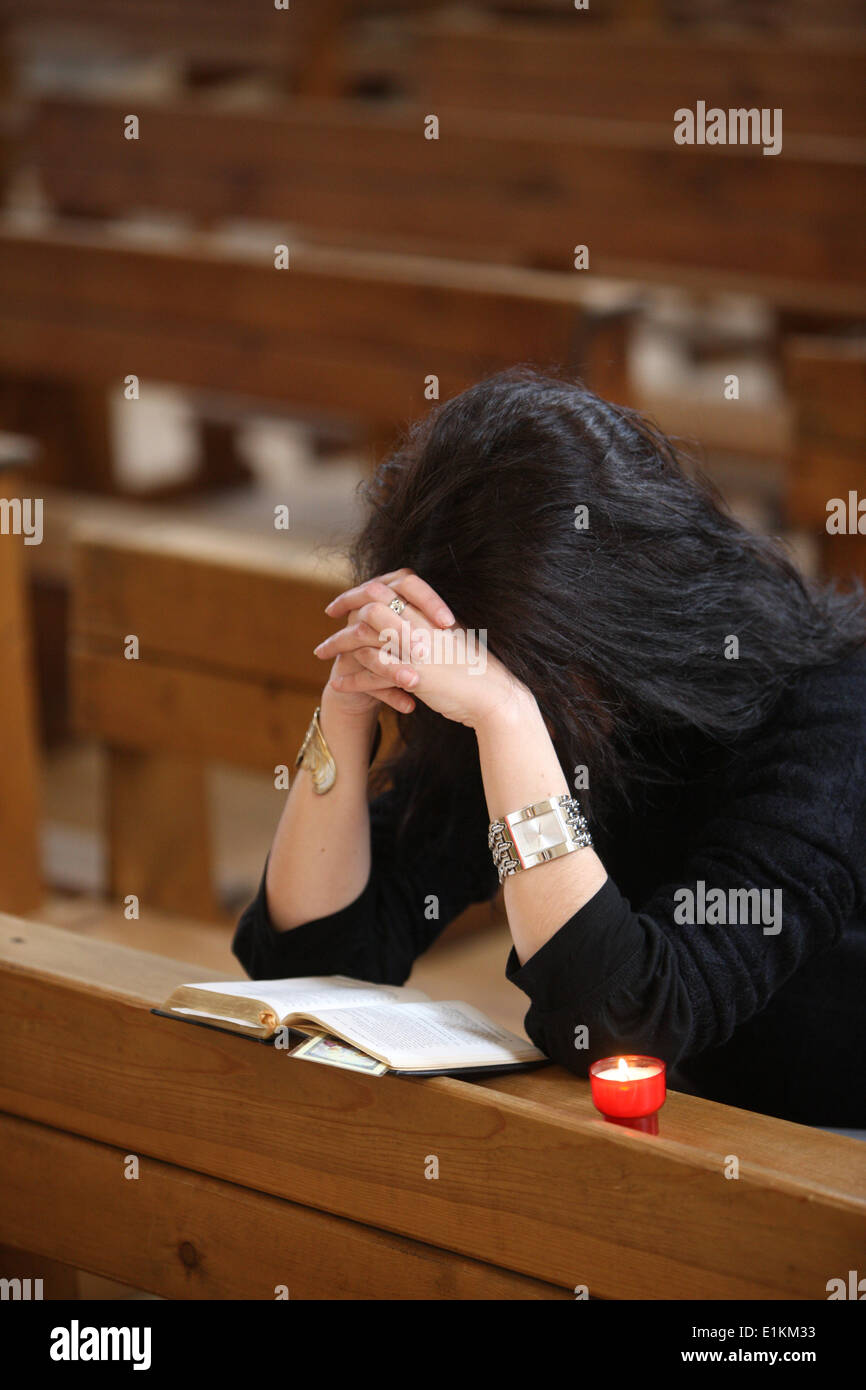 Woman praying in a church Stock Photo - Alamy
