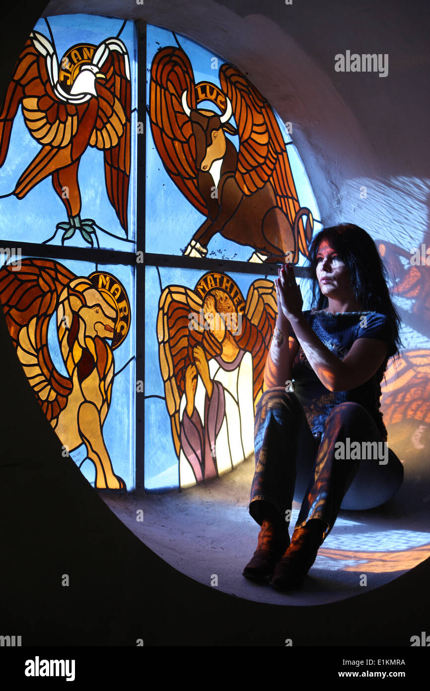 Woman praying in front of a glass window Stock Photo - Alamy