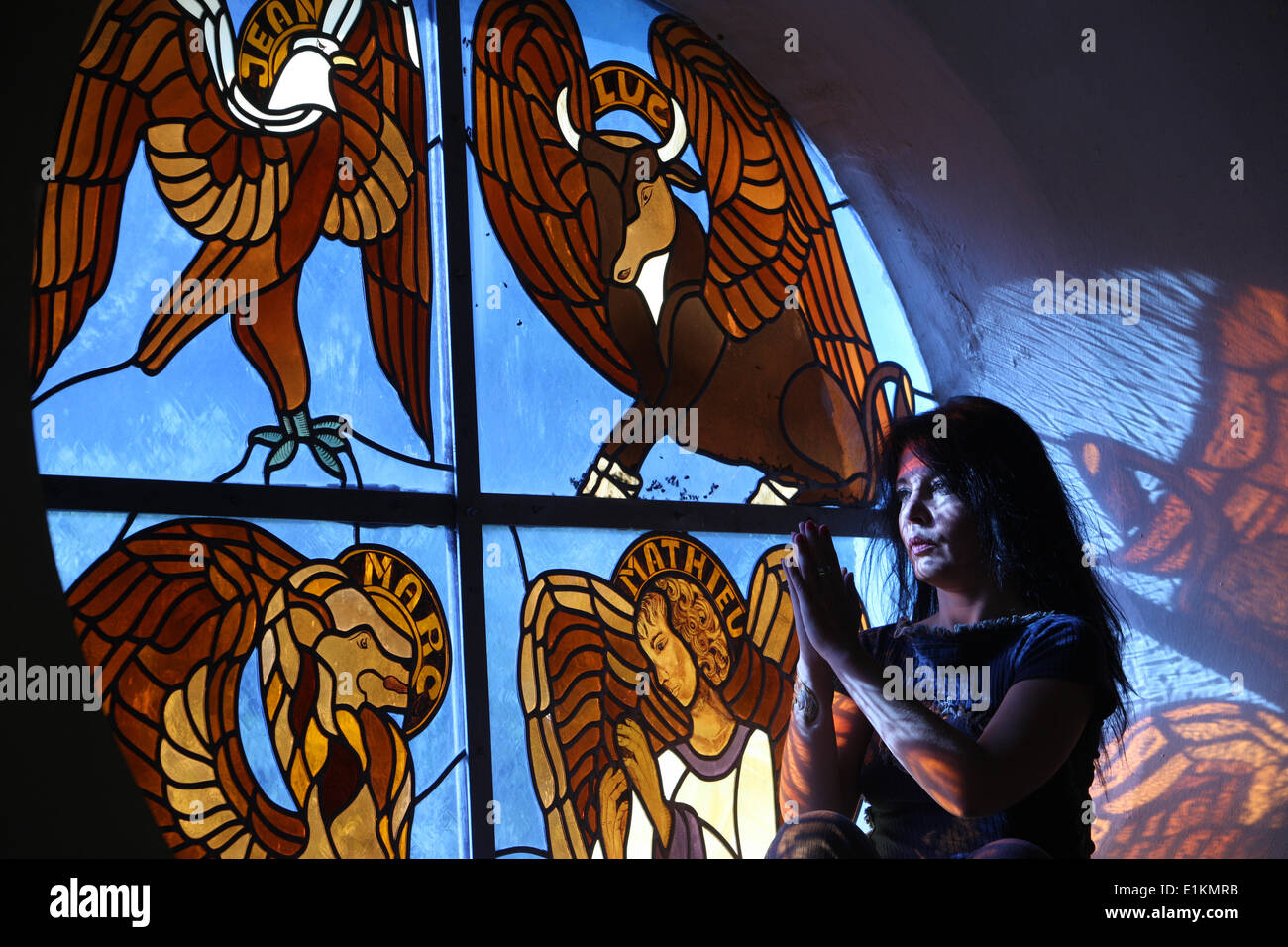 Woman praying in front of a glass window Stock Photo - Alamy