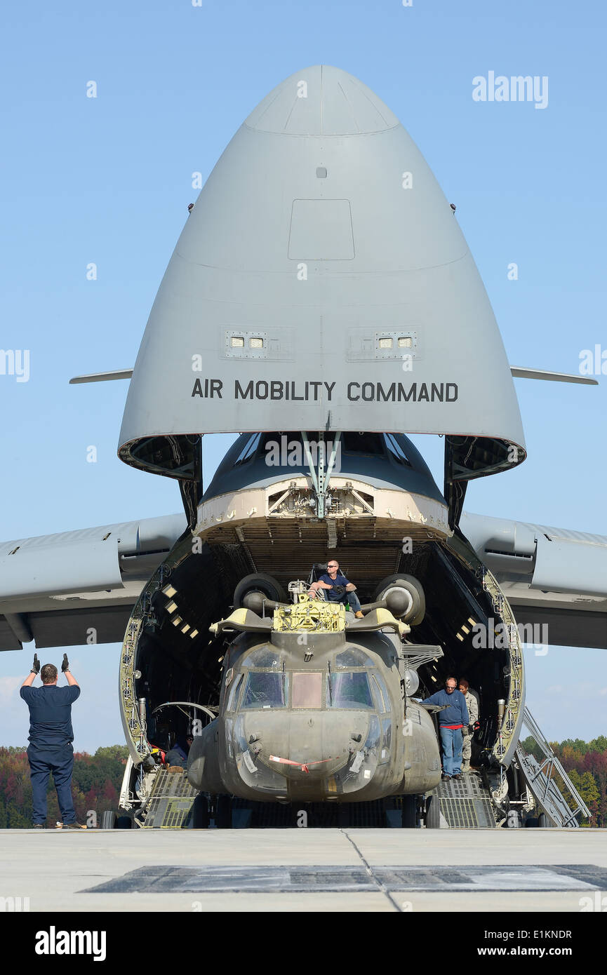 U.S. Airmen unload an Army CH-47 Chinook helicopter from an Air Force C ...