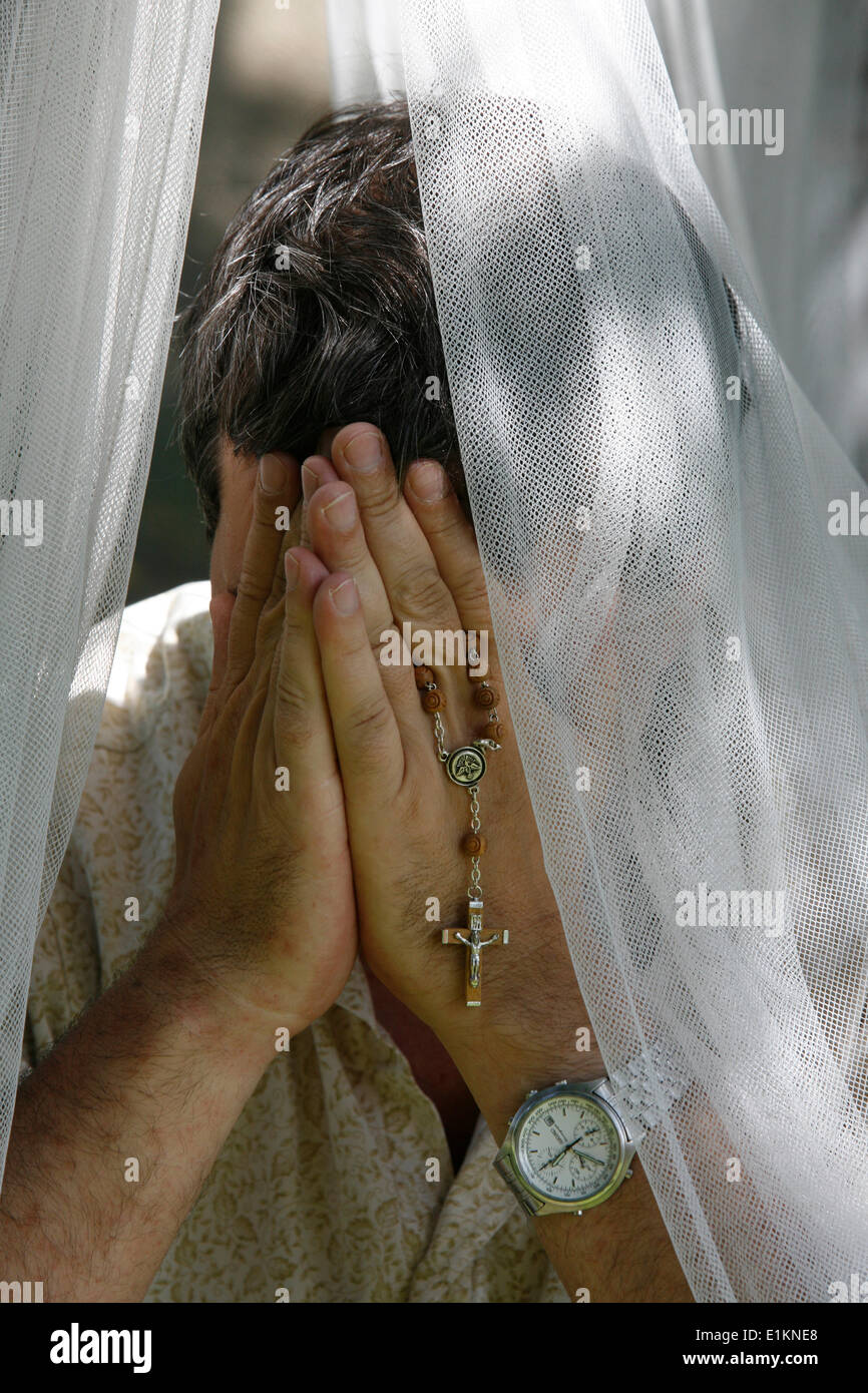 Man praying with rosary Stock Photo - Alamy