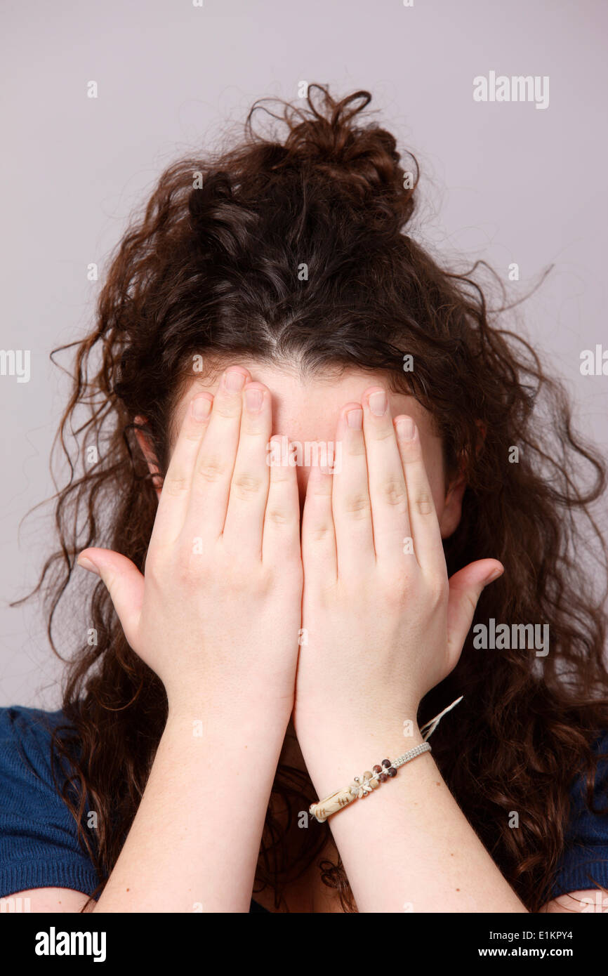 Young woman hiding her face Stock Photo - Alamy