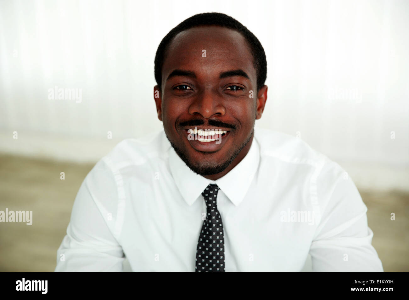 Portrait of a laughing african man in office Stock Photo - Alamy