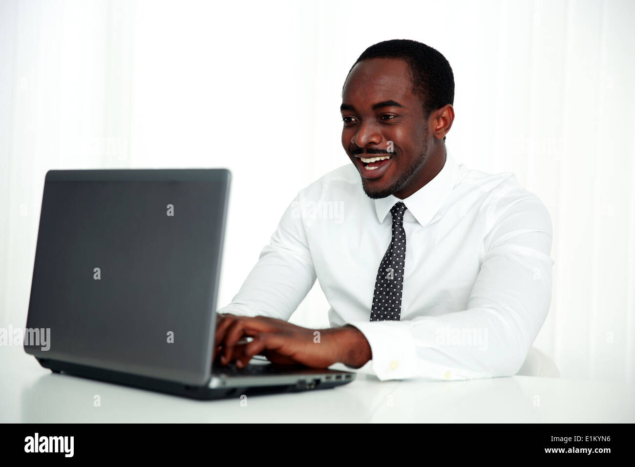 Laughing black man using laptop hi-res stock photography and images - Alamy