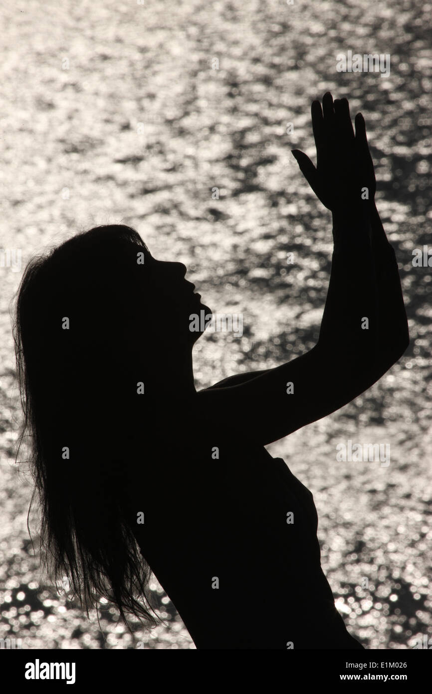 Woman praying at sunset Stock Photo - Alamy