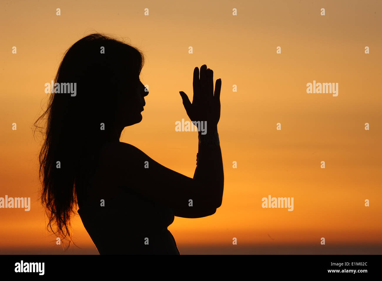 Woman praying at sunset hi-res stock photography and images - Alamy