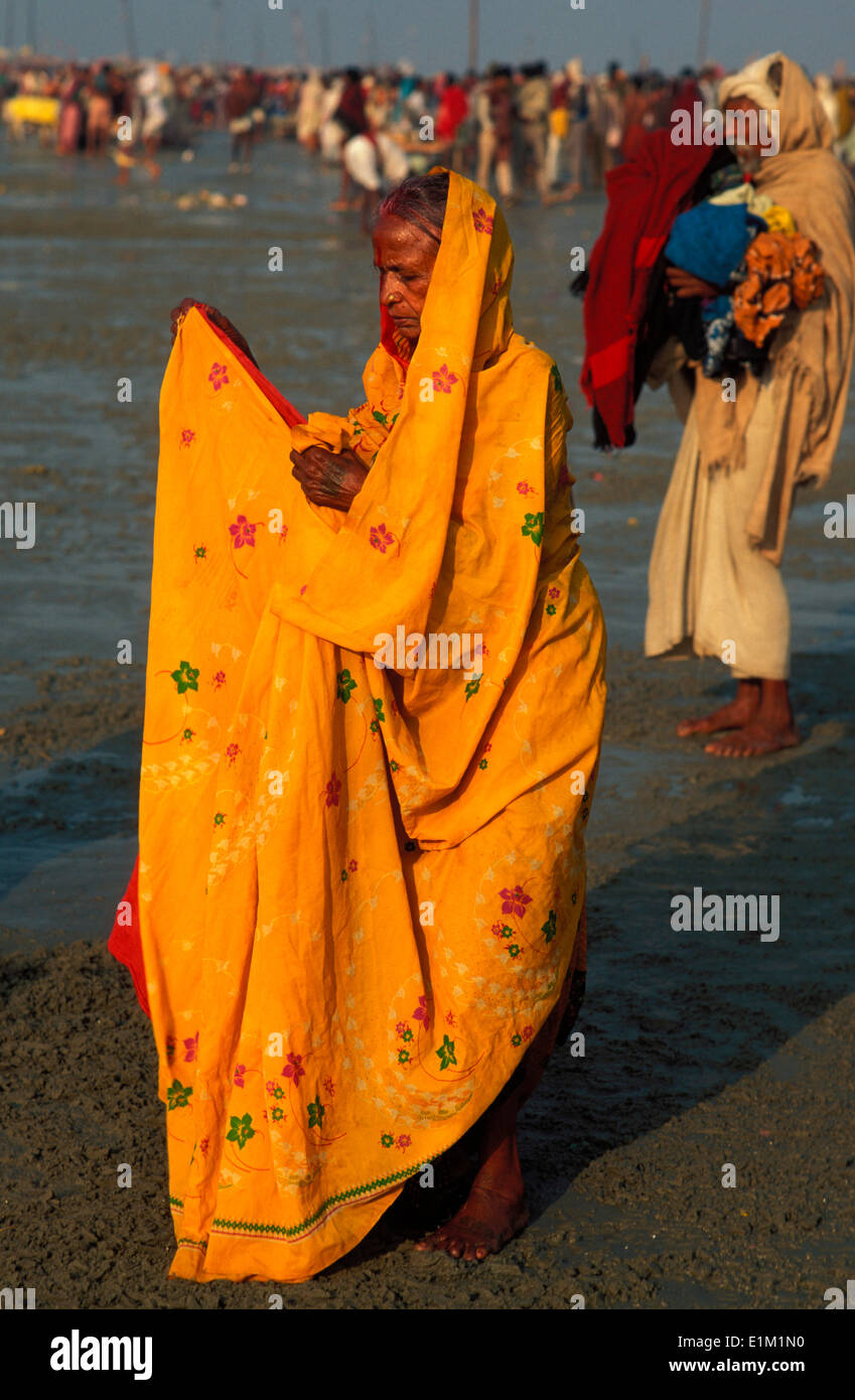 Hindu pilgrim drying her sari after a ritual dip in the Ganges at Ganga ...