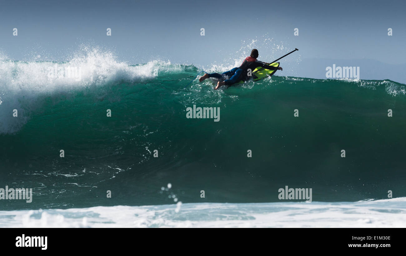 Stand up paddle surfer swimming over a wave Stock Photo - Alamy