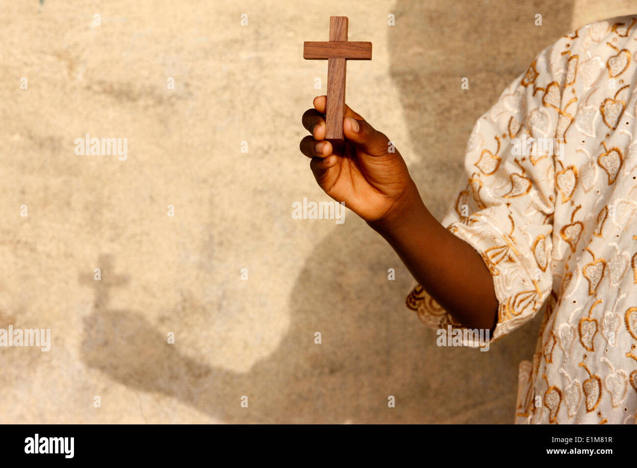 Young African christian holding a cross Stock Photo - Alamy