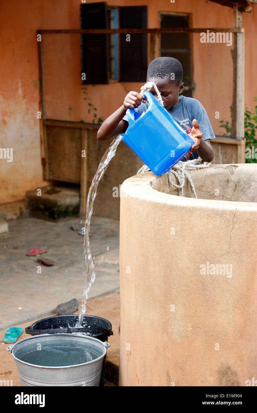 Boy using a well in Togo Stock Photo - Alamy
