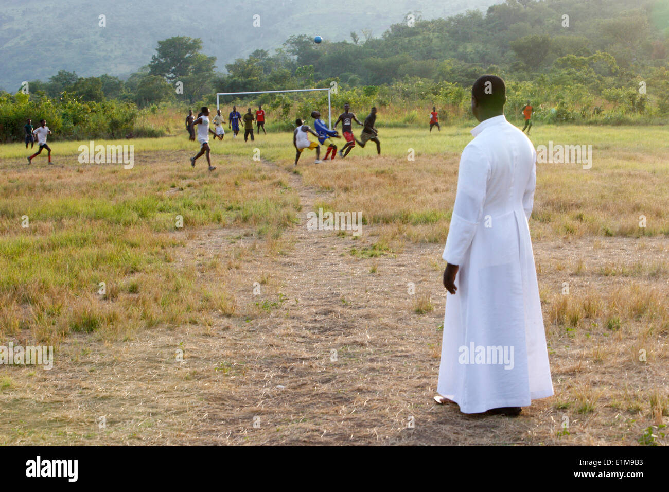 Catholic priest watching a soccer game Stock Photo - Alamy